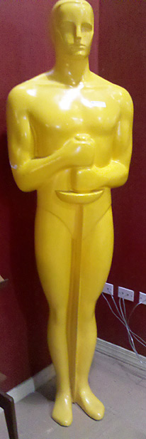 A big yellow statue that looks like an Oscar - Auction Finds