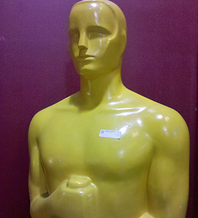 A big yellow statue that looks like an Oscar - Auction Finds